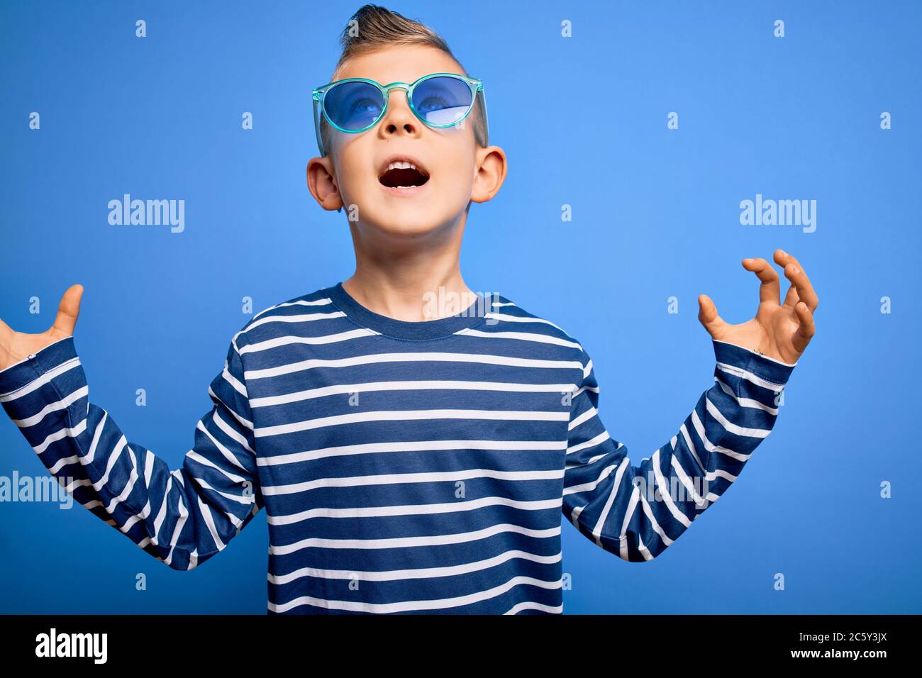 Young little caucasian kid with blue eyes standing wearing sunglasses ...