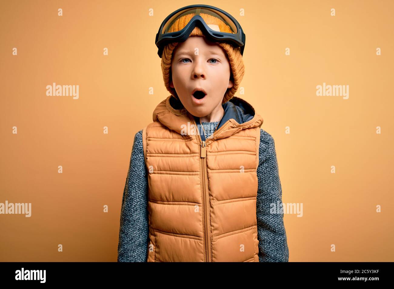 Young little caucasian kid wearing snow glasses and winter coat over ...