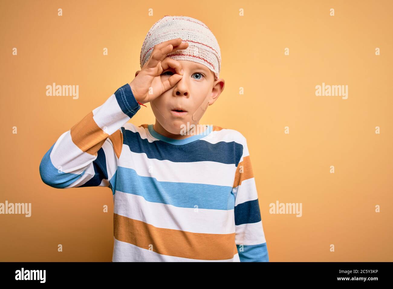 Young little caucasian kid injured wearing medical bandage on head over ...