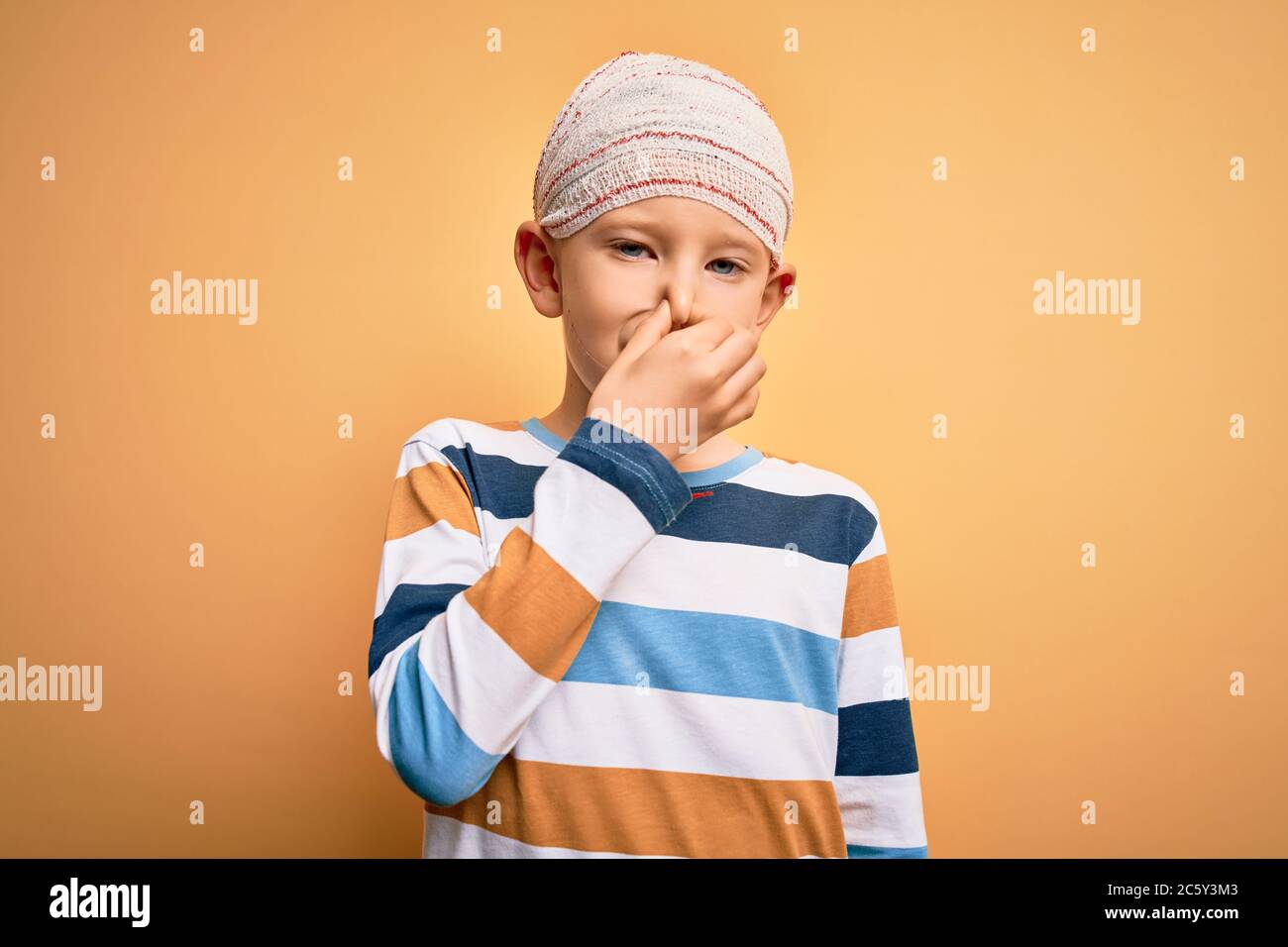 Young little caucasian kid injured wearing medical bandage on head over ...