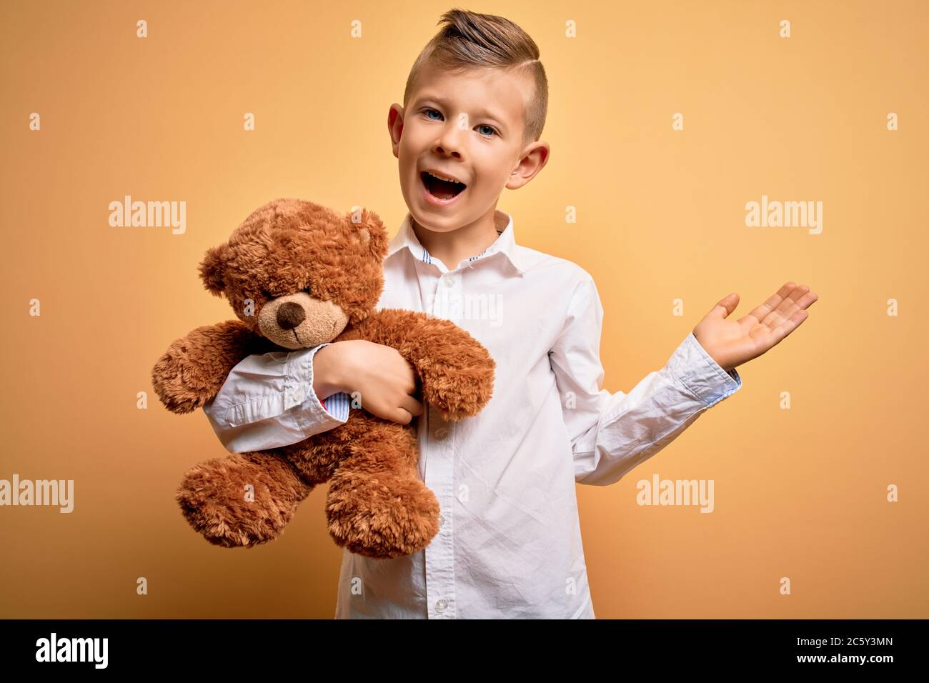 Young little caucasian kid hugging teddy bear stuffed animal over ...