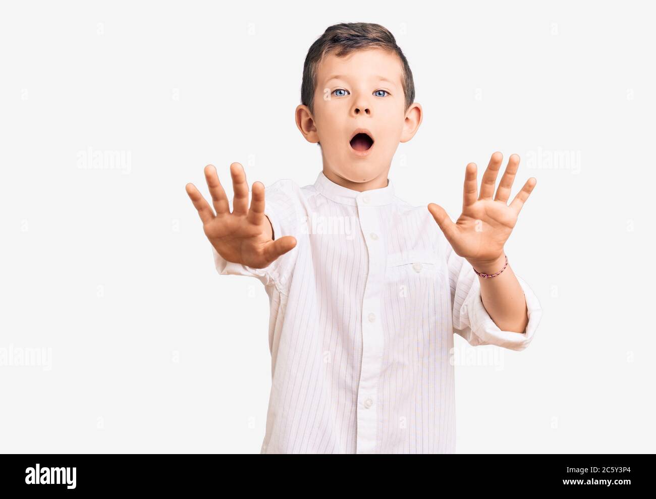 Cute blond kid wearing elegant shirt afraid and terrified with fear ...