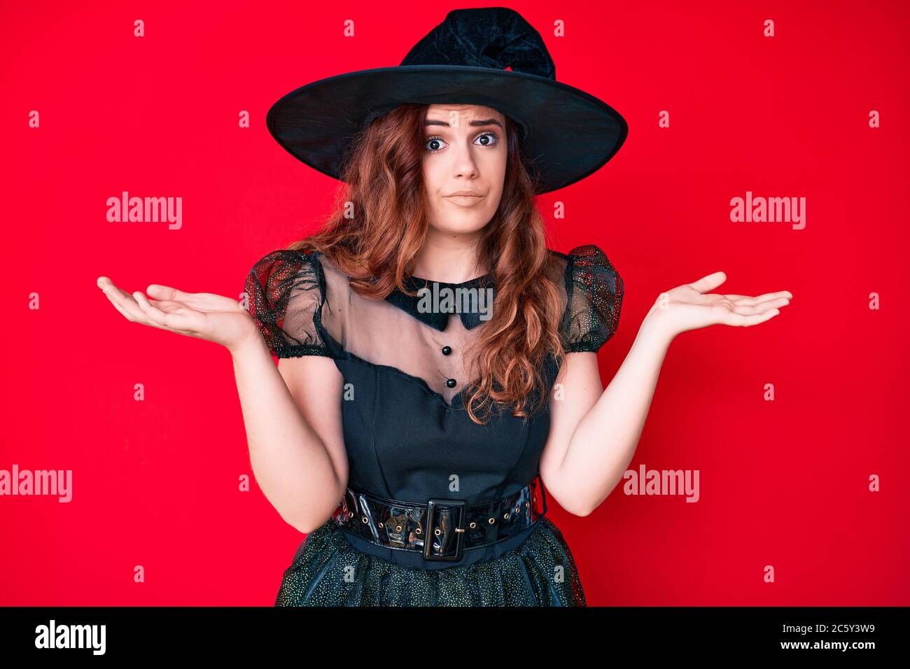 Young beautiful woman wearing witch halloween costume clueless and ...