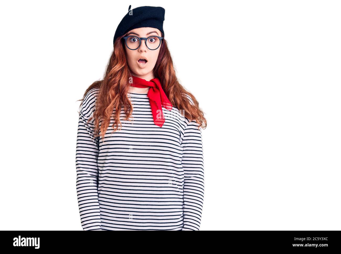 Young beautiful woman wearing french look with beret scared and amazed ...