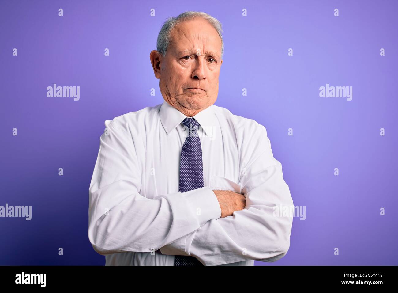 Grey haired senior business elegant man standing over purple isolated ...