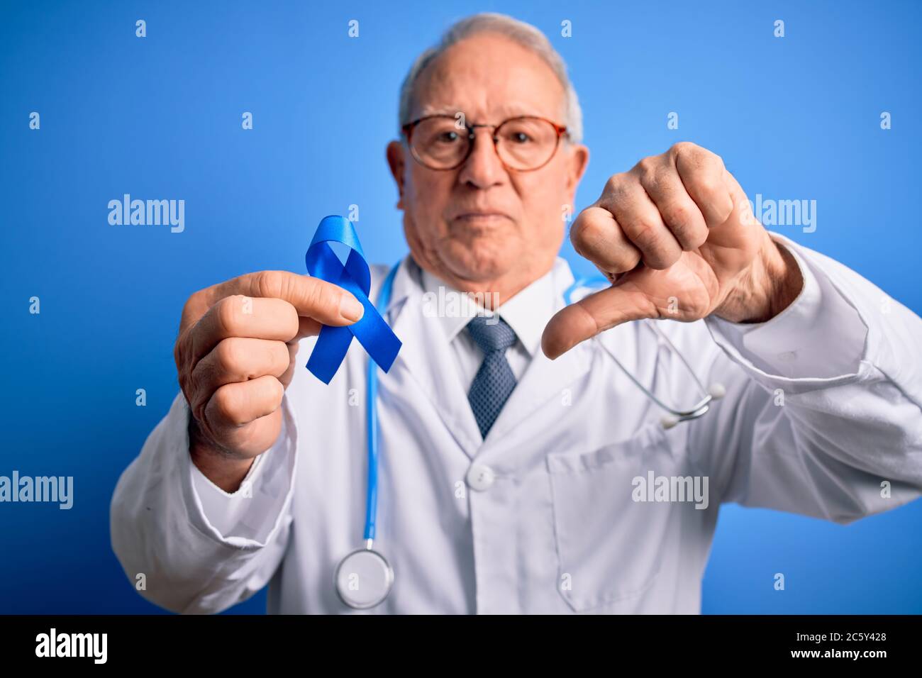 Grey haired senior doctor man holding colon cancer awareness blue ...