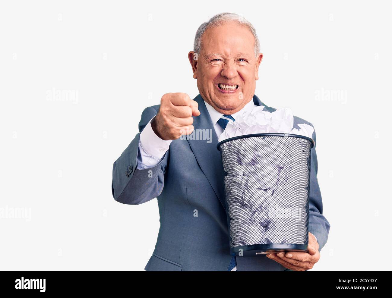 Senior handsome grey-haired man holding paper bin with crumpled ...