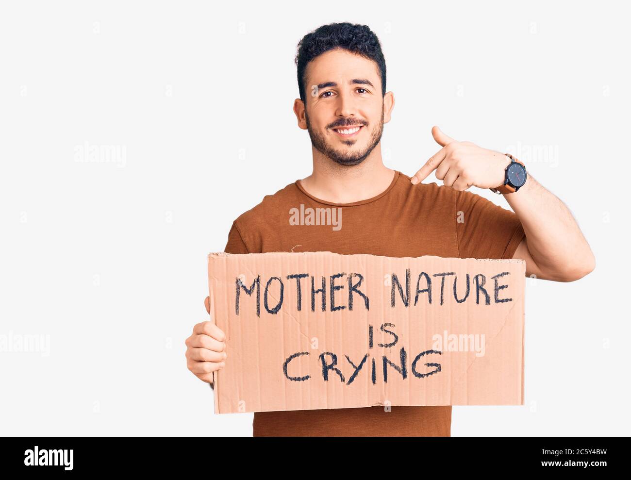Young hispanic man holding mother nature is crying protest cardboard ...