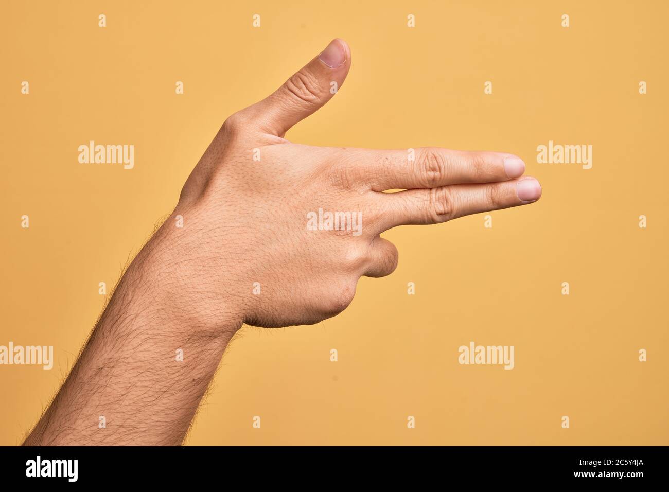 Hand of caucasian young man showing fingers over isolated yellow ...