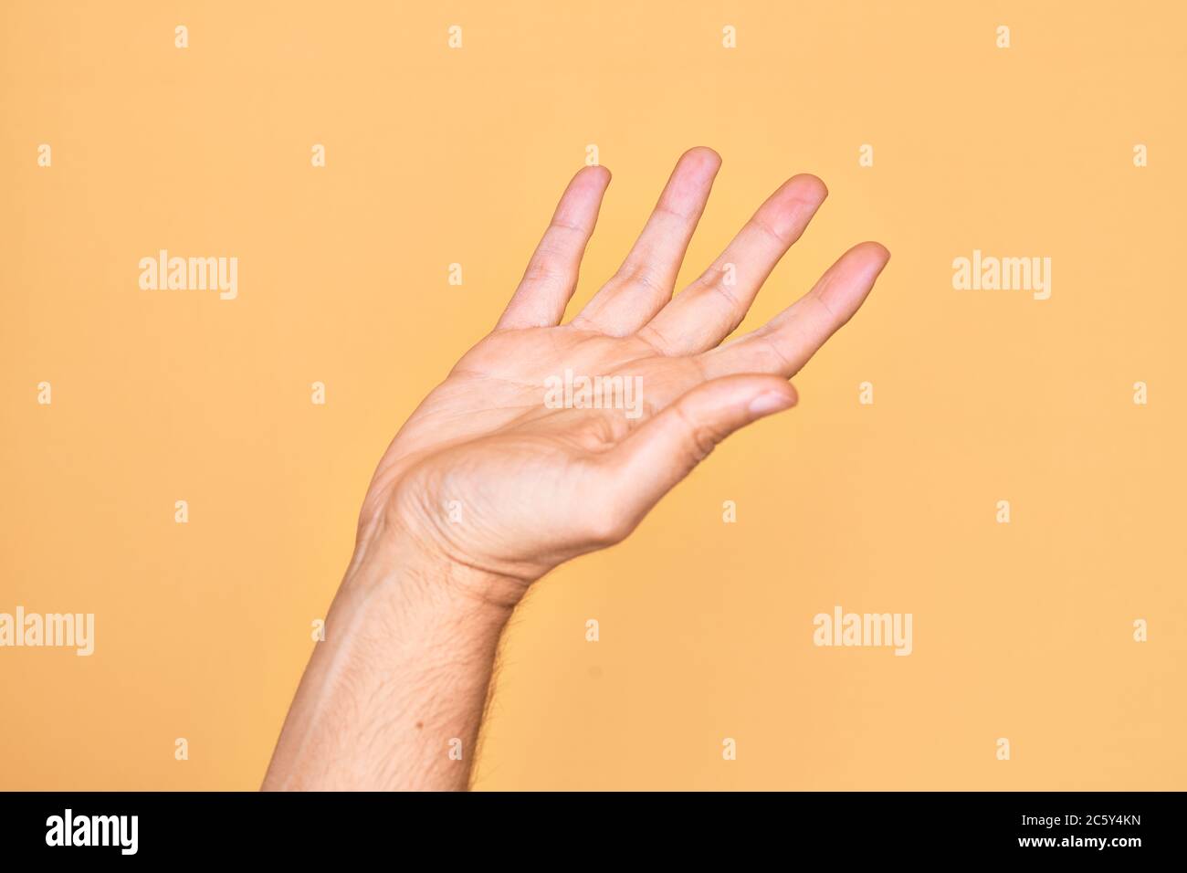 Hand of caucasian young man showing fingers over isolated yellow ...