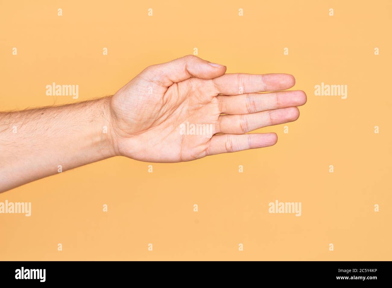 Hand of caucasian young man showing fingers over isolated yellow ...