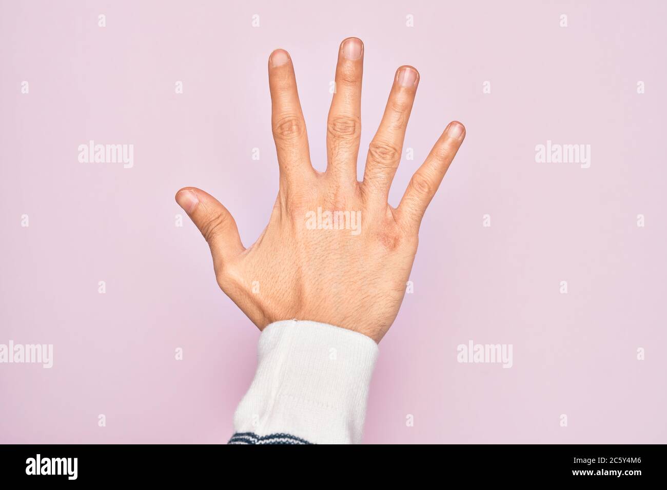 Hand of caucasian young man showing fingers over isolated pink ...