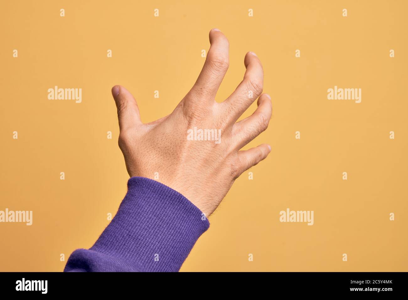 Hand of caucasian young man showing fingers over isolated yellow ...