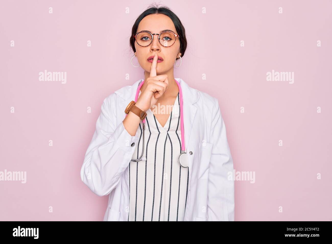 Beautiful doctor woman with blue eyes wearing coat and stethoscope over ...