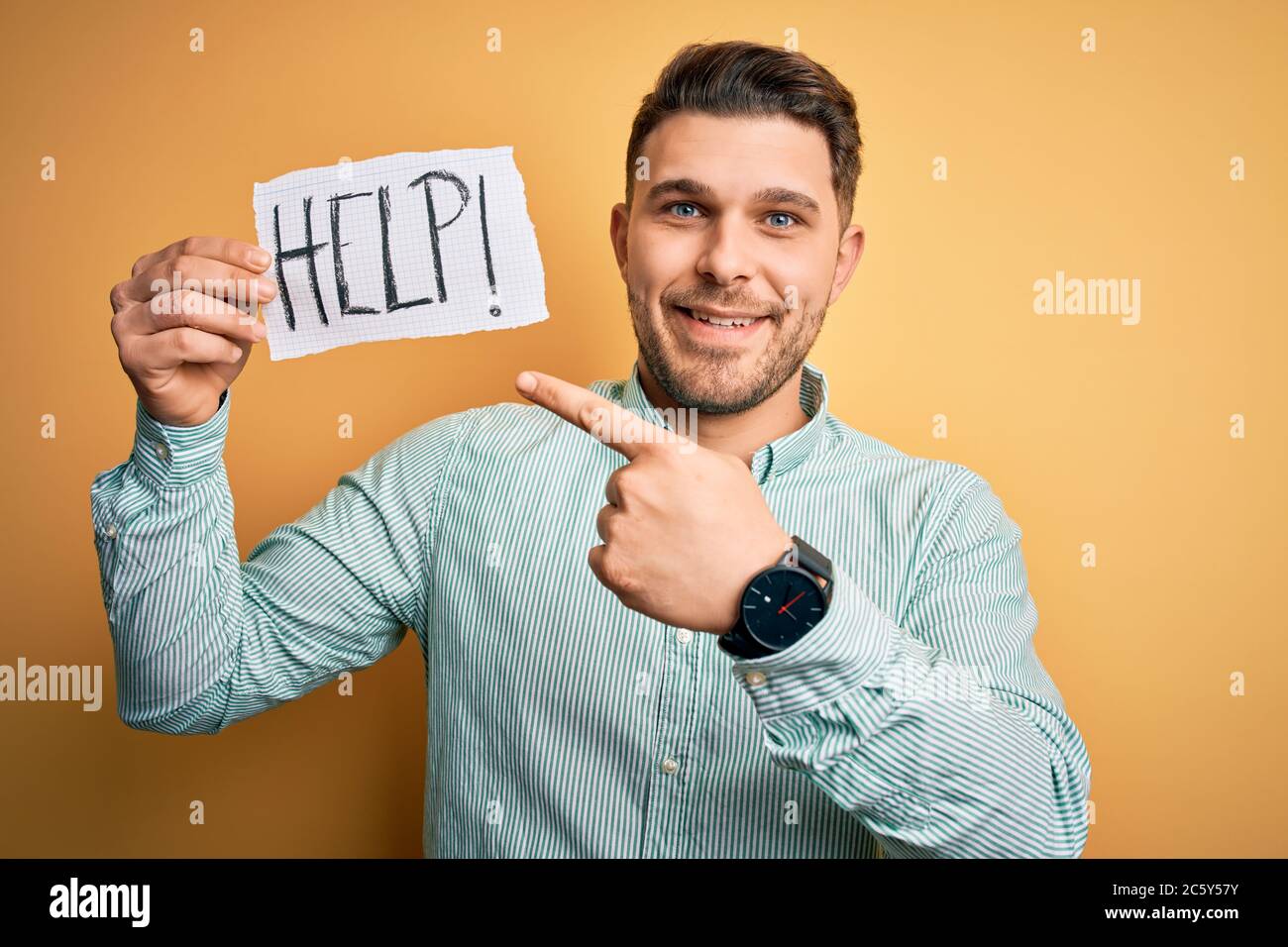 Young business man with blue eyes asking for help holding paper note ...