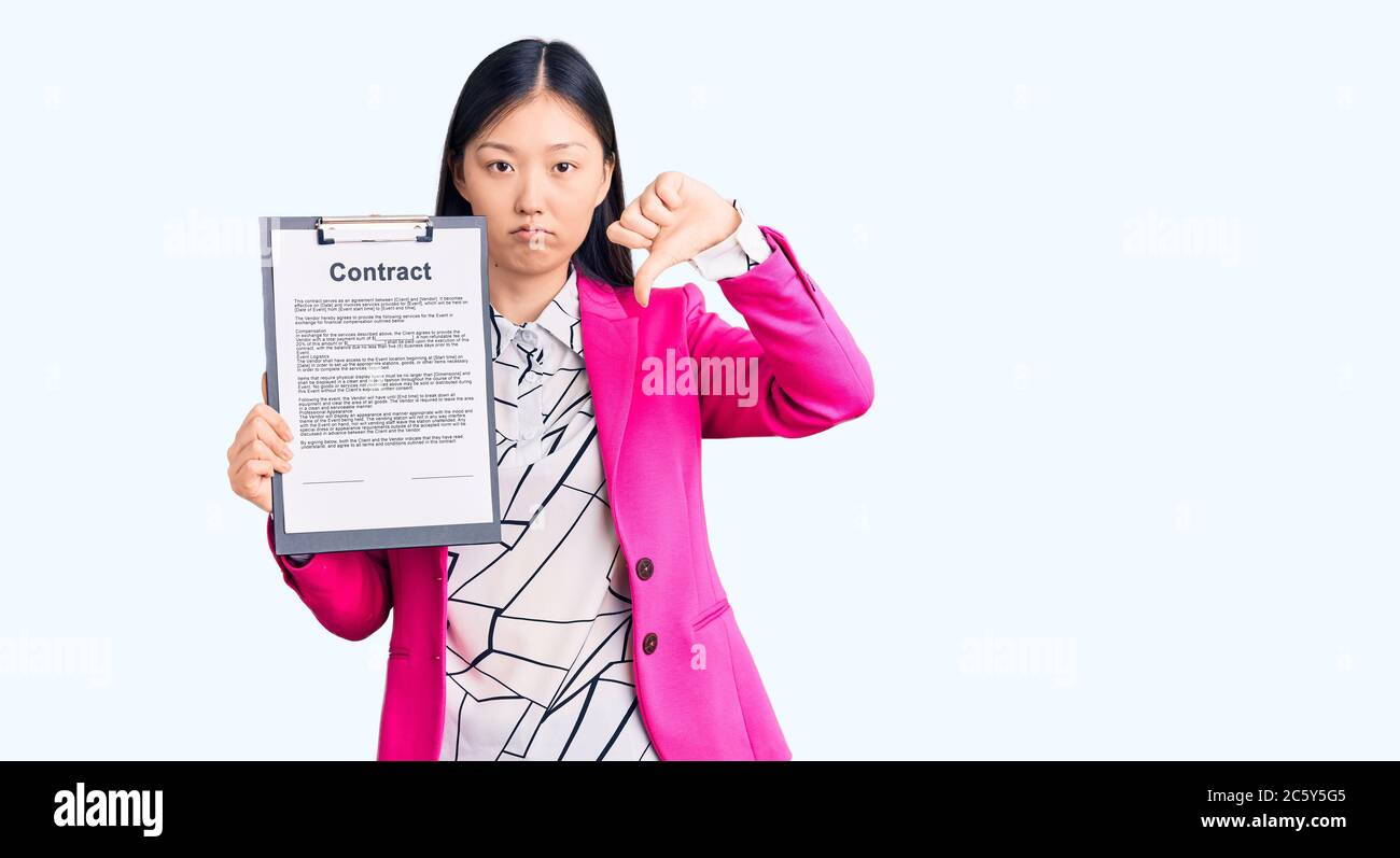 Young beautiful chinese woman holding clipboard with contract document ...