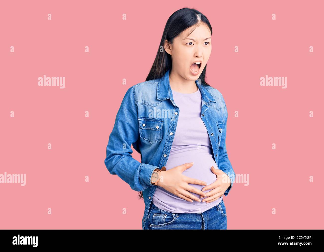 Young beautiful chinese woman pregnant expecting baby angry and mad ...