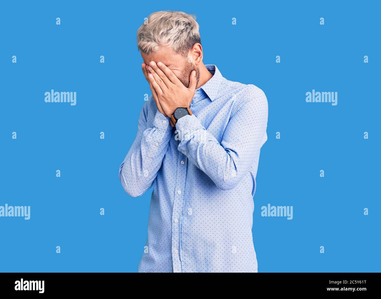 Young handsome blond man wearing elegant shirt with sad expression ...