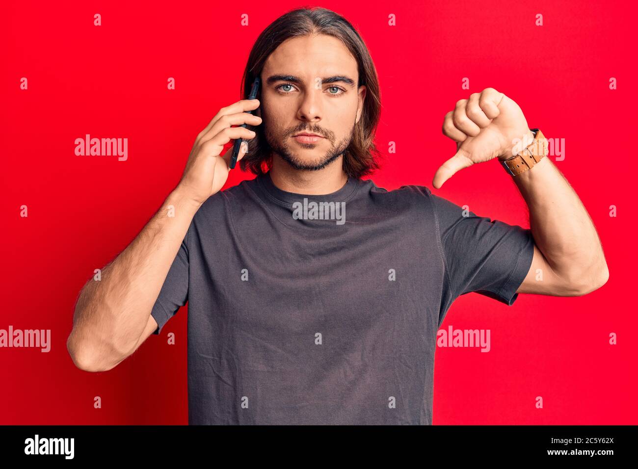 Young handsome man having conversation talking on the smartphone with ...