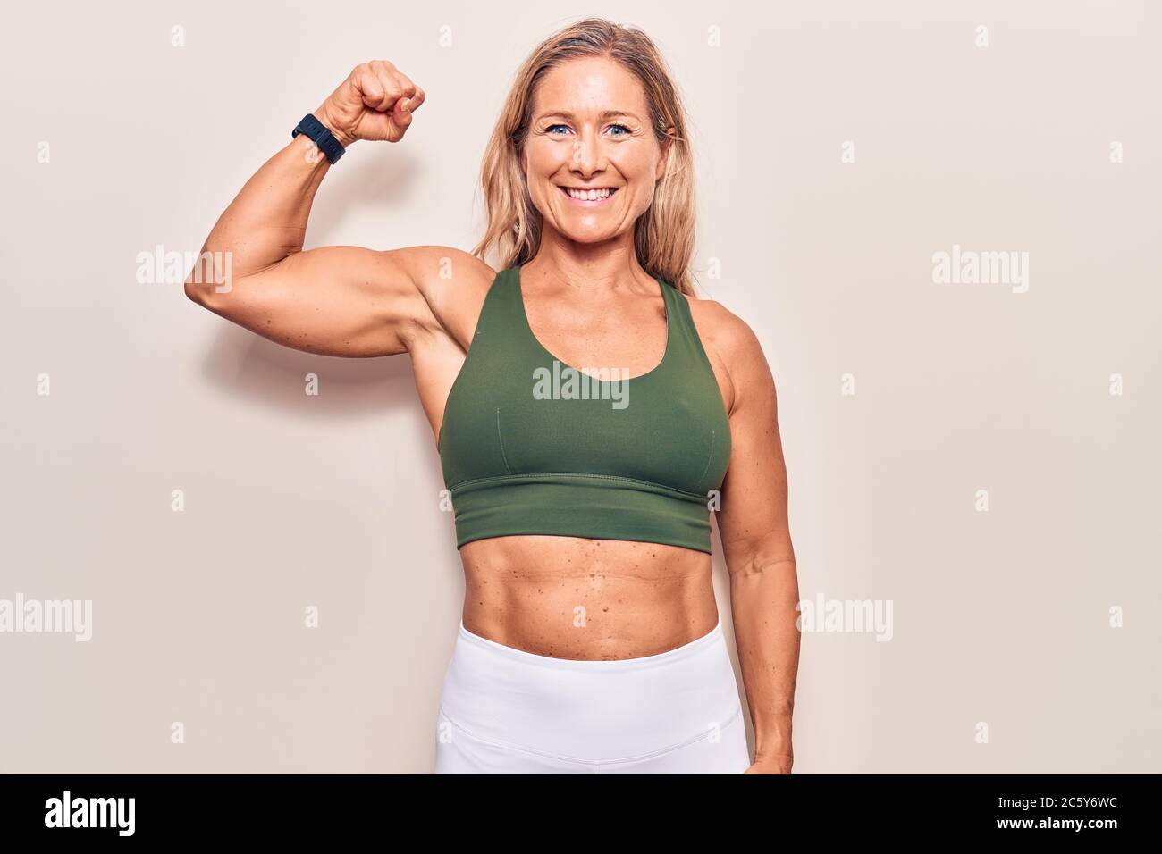 Blonde caucasian middle age sports woman posing and showing arms ...