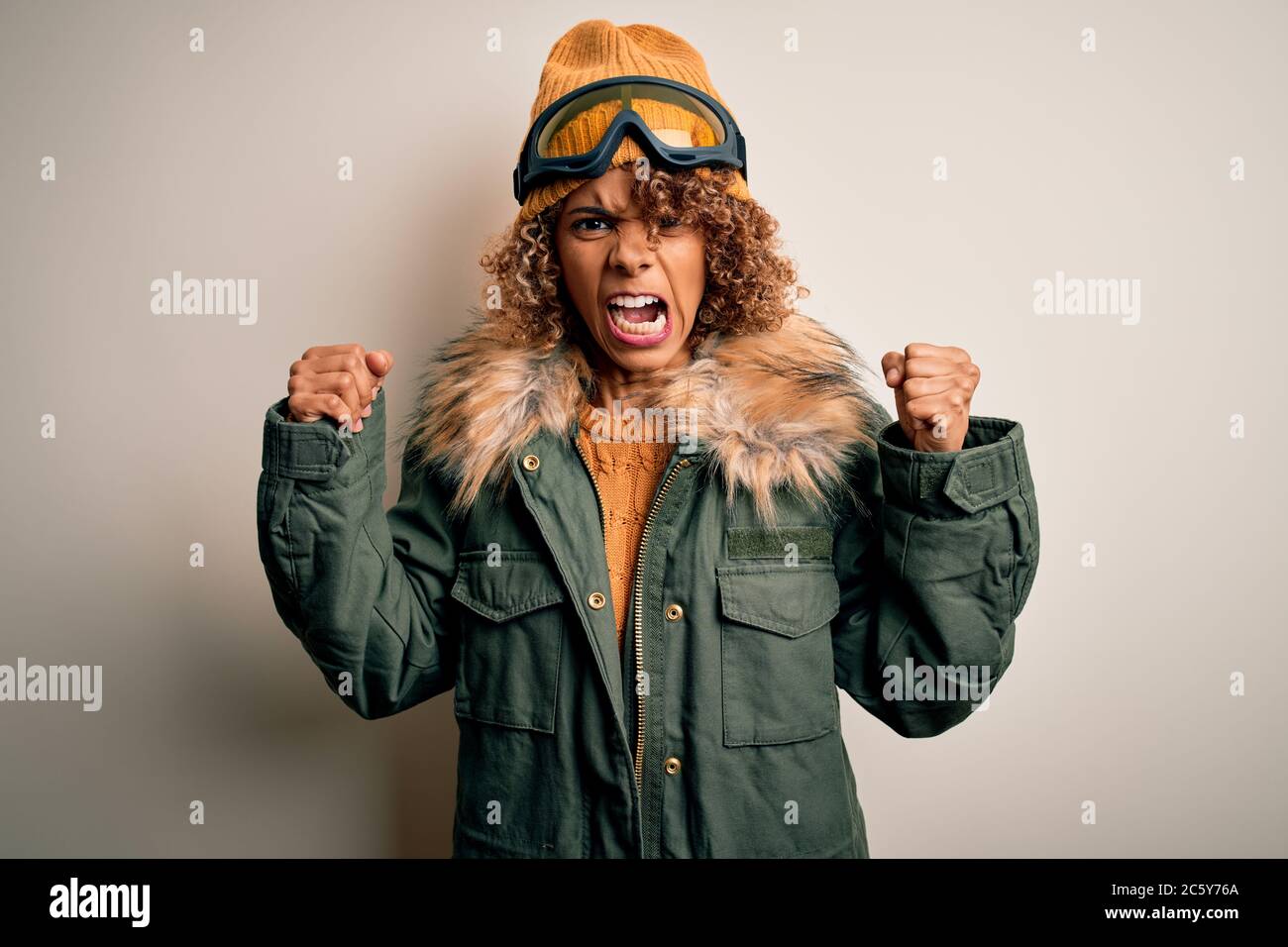 Young african american skier woman with curly hair wearing snow ...