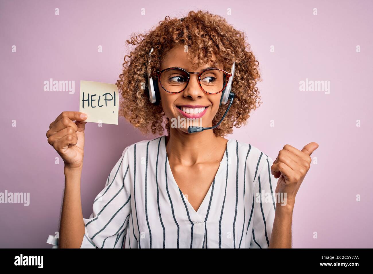 African american call center agent woman using headset holding paper ...