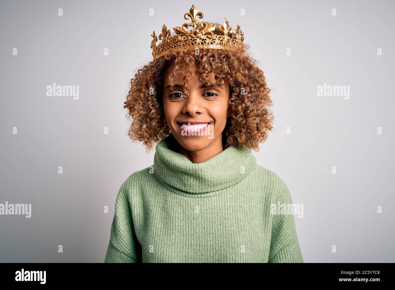 Young african american woman wearing golden crown of queen over ...