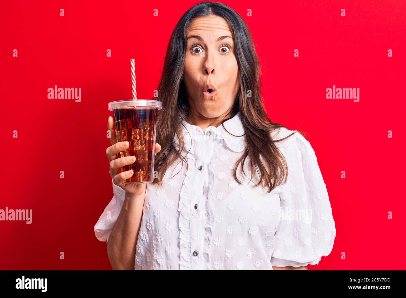 Beautiful brunette woman drinking cola refreshment beverage using straw ...