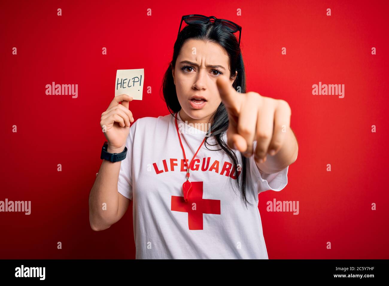 Young lifeguard woman holding paper note with help word over red ...