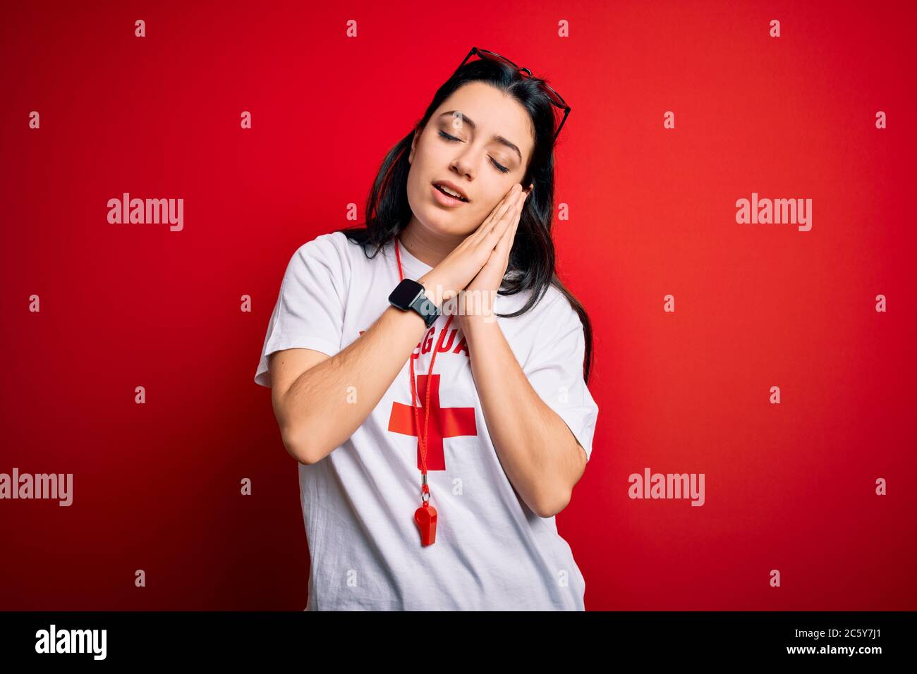 Young lifeguard woman wearing secury guard equipent over red background ...