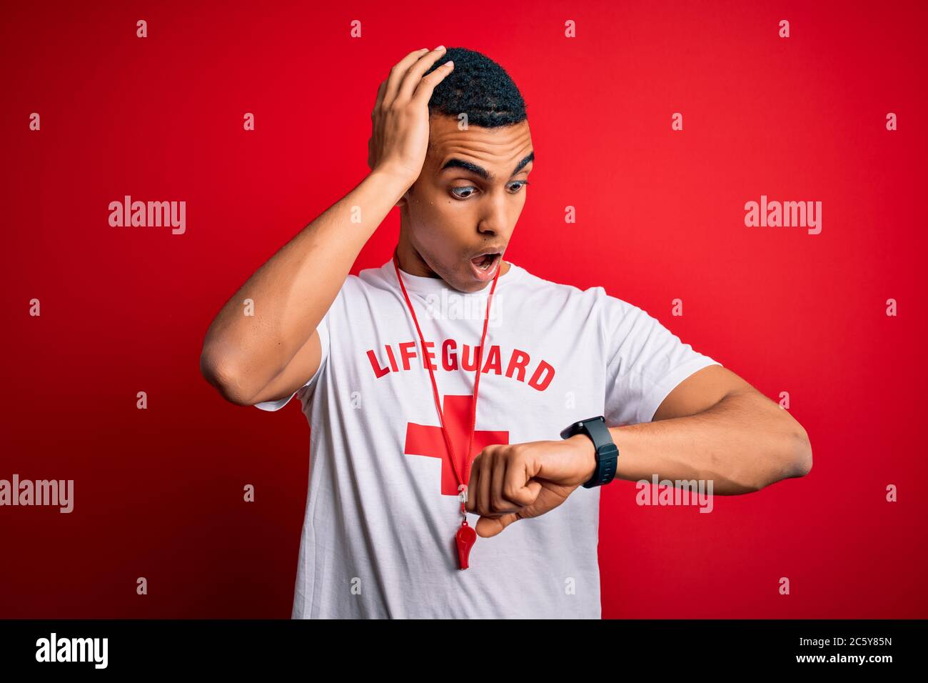 Young handsome african american lifeguard man wearing t-shirt with red ...