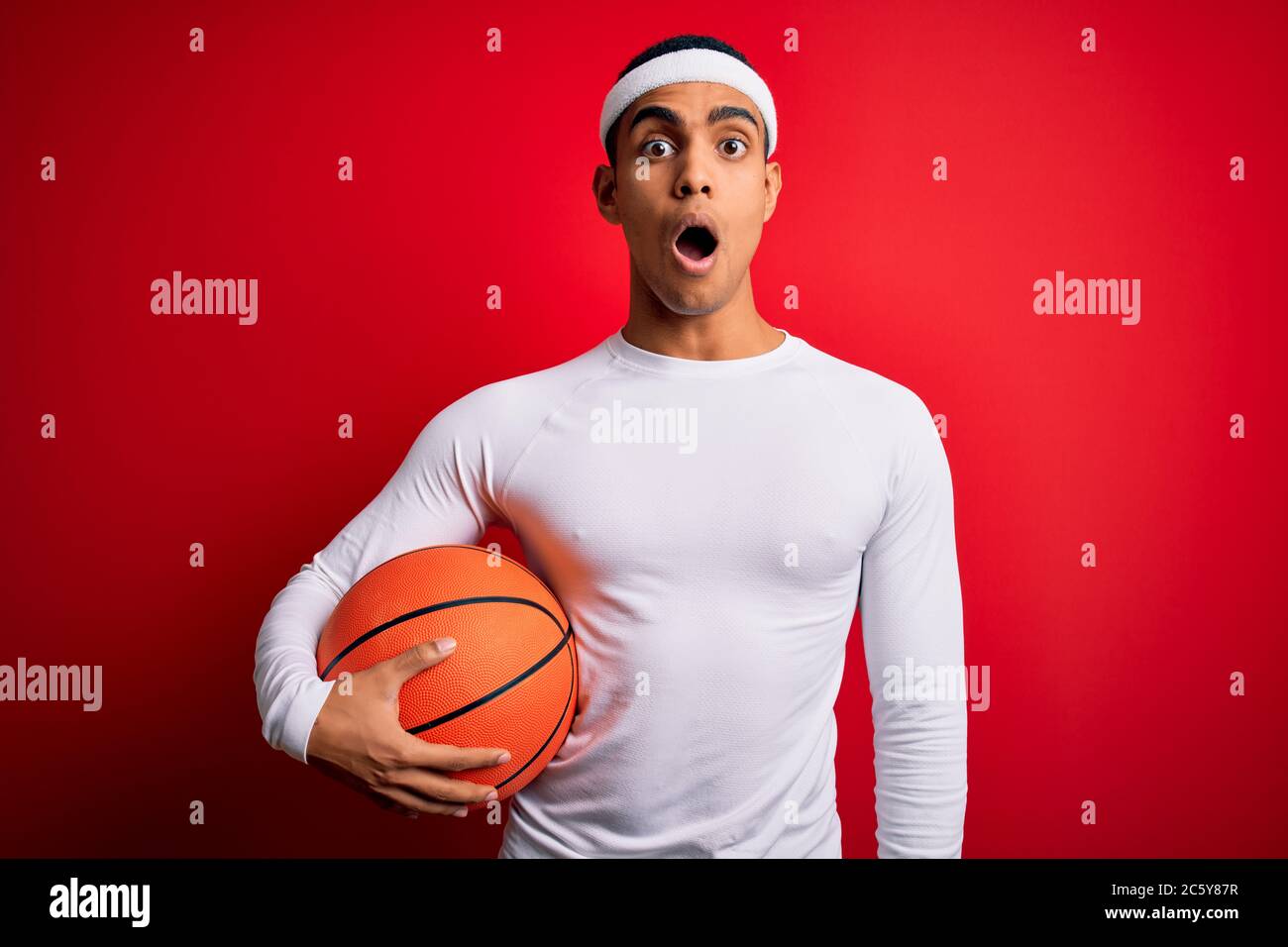 Young handsome african american sportsman holding basketball ball over ...