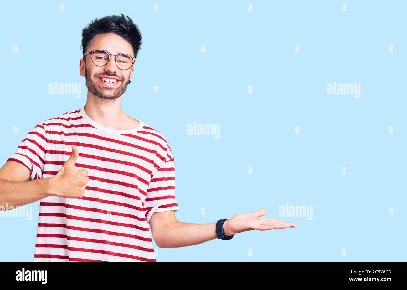 Young hispanic man wearing casual clothes showing palm hand and doing ...