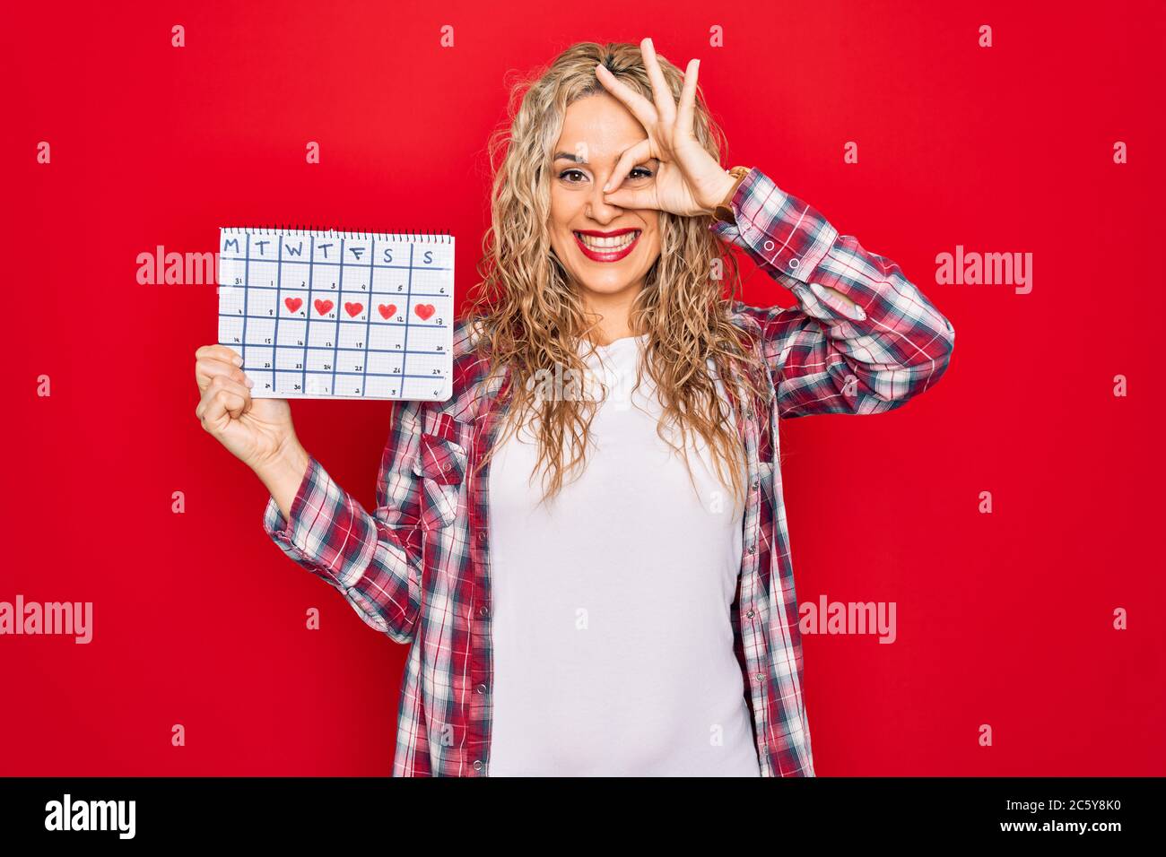 Young beautiful blonde woman holding period calendar controlling ...
