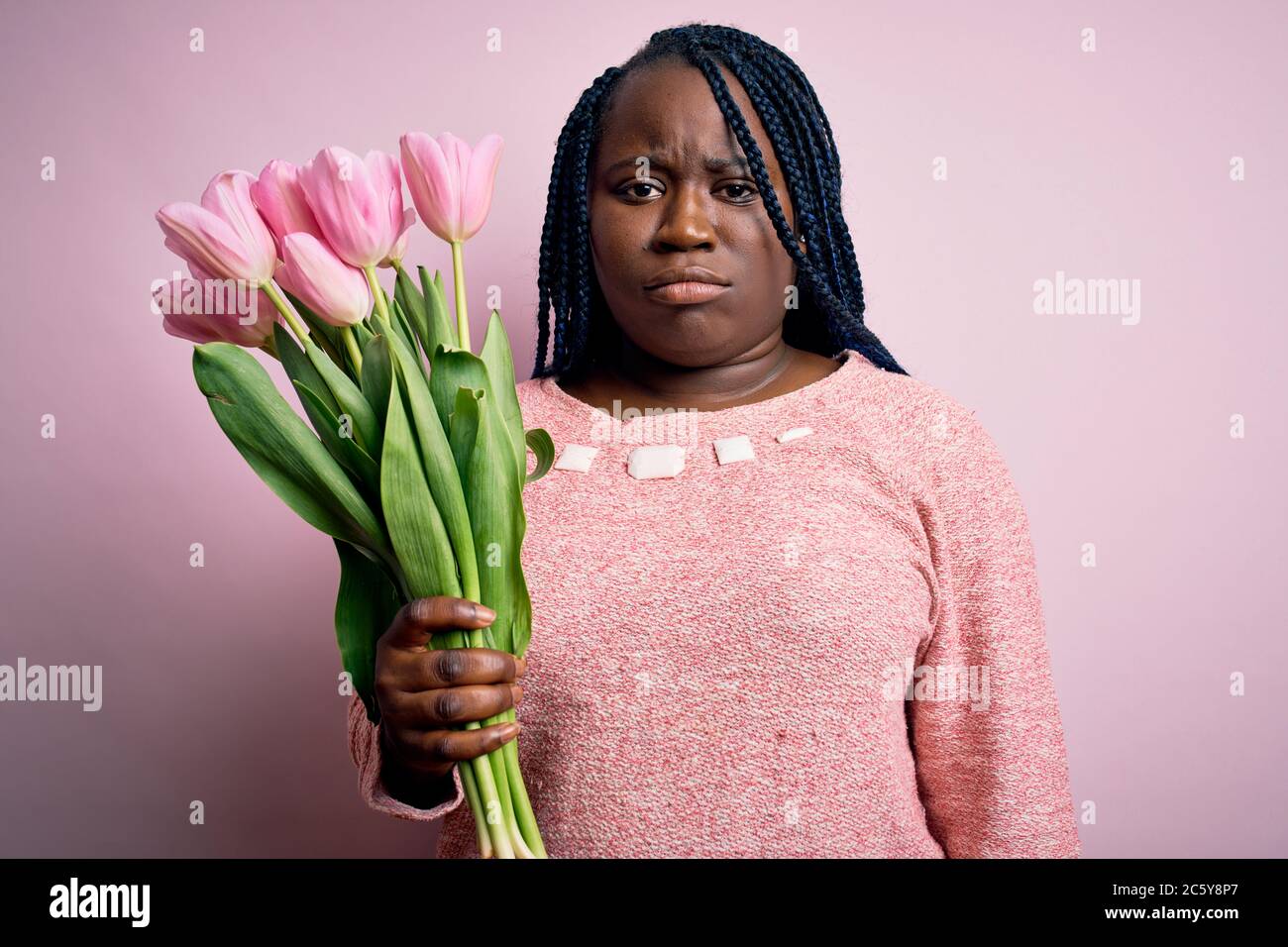 Young african american plus size woman with braids holding bouquet of ...