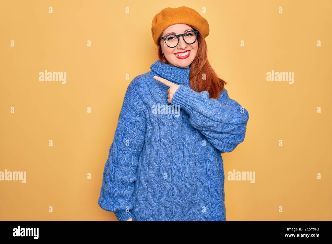 Young beautiful redhead woman wearing french beret and glasses over ...