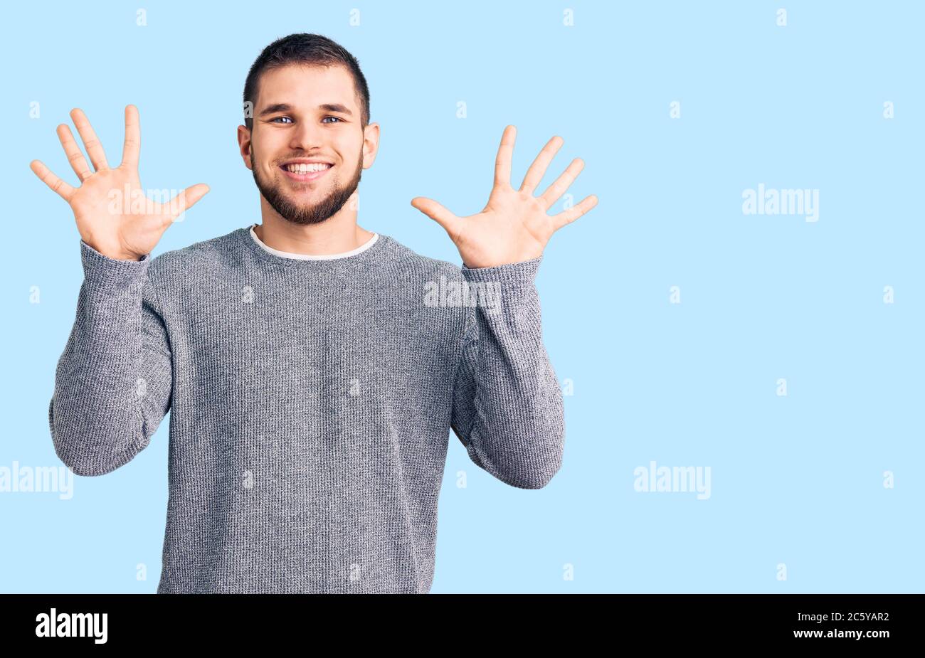 Young handsome man wearing casual sweater showing and pointing up with ...
