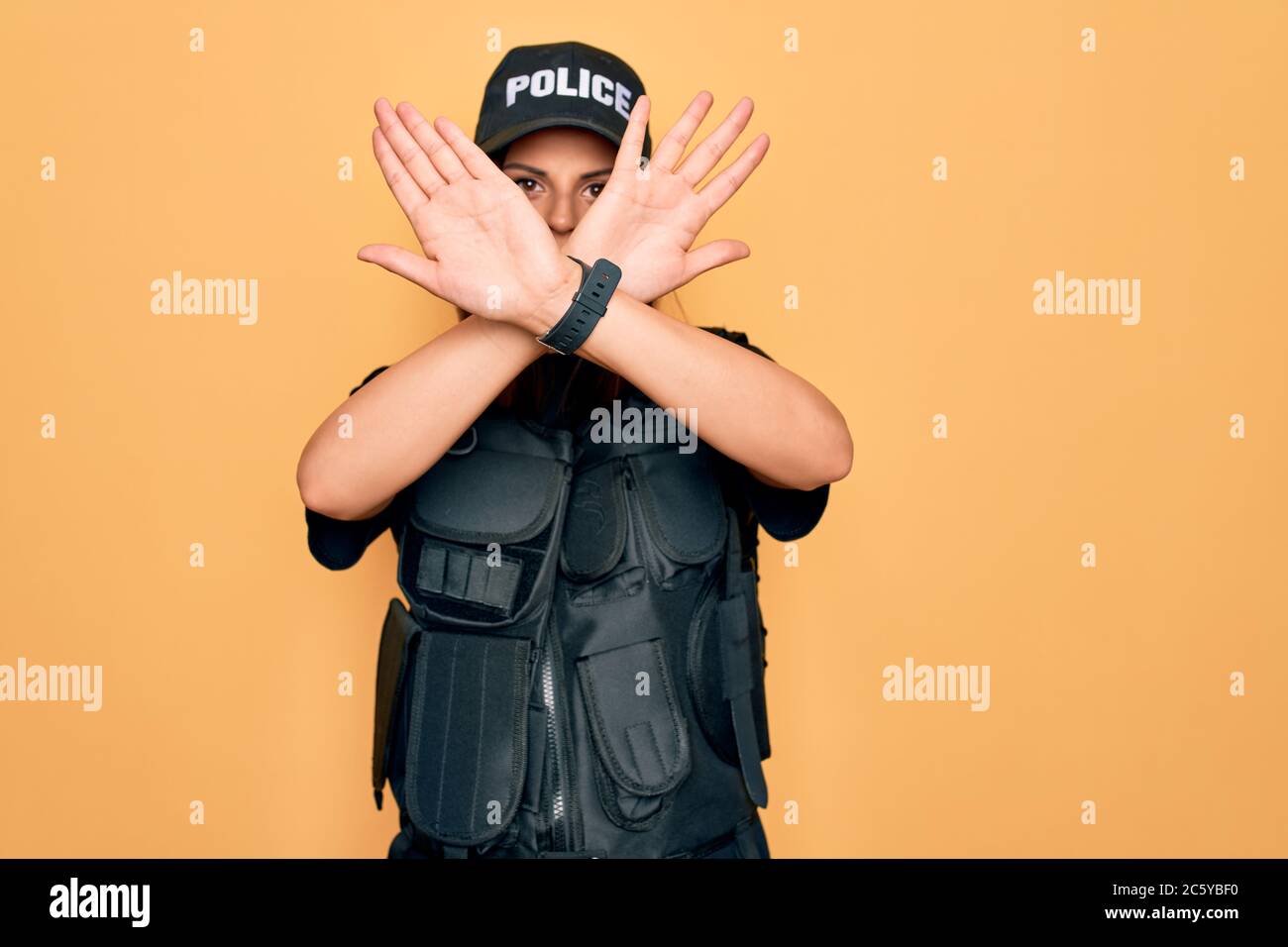 Young beautiful brunette policewoman wearing police uniform bulletproof ...