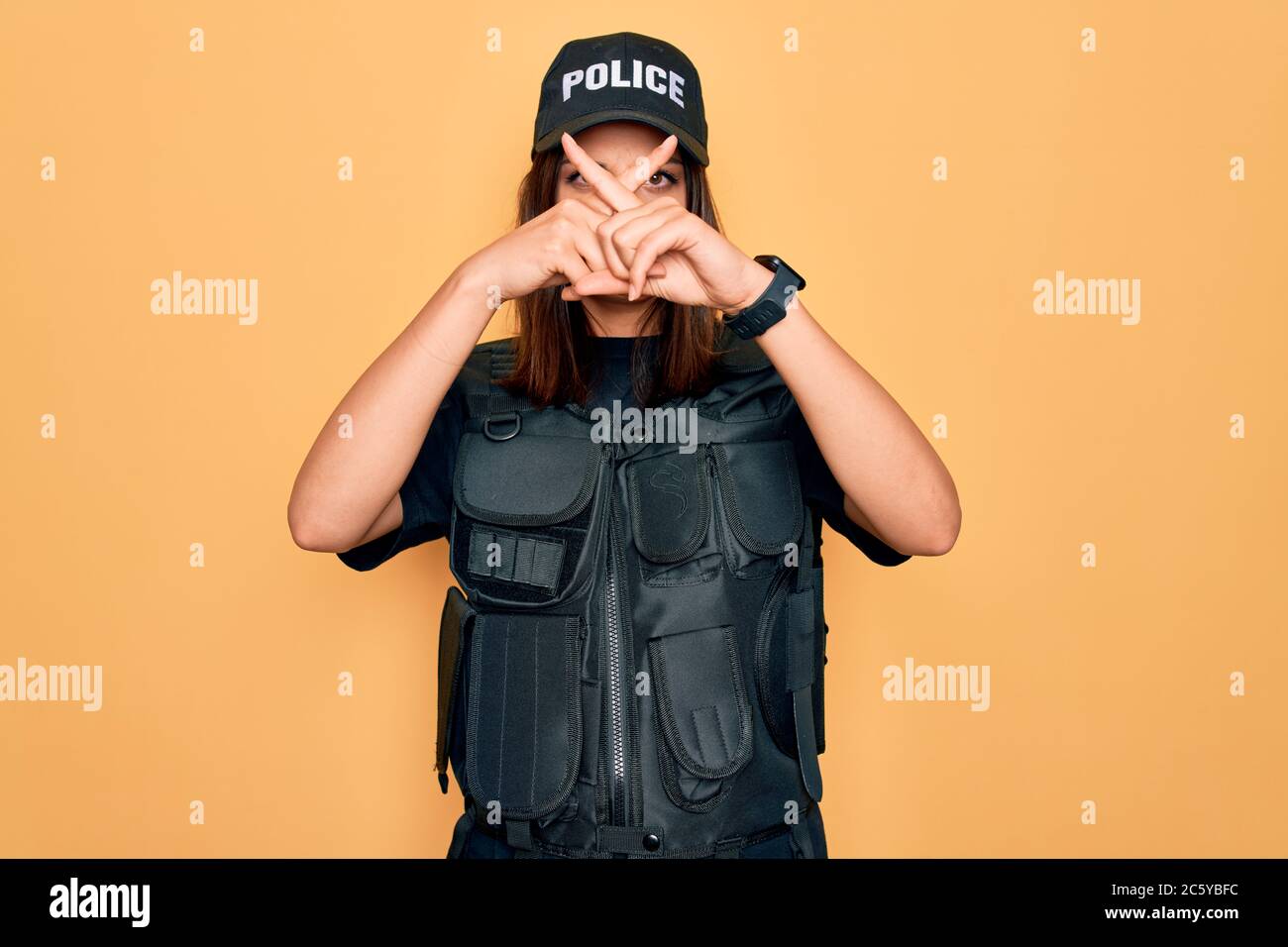 Young beautiful brunette policewoman wearing police uniform bulletproof ...
