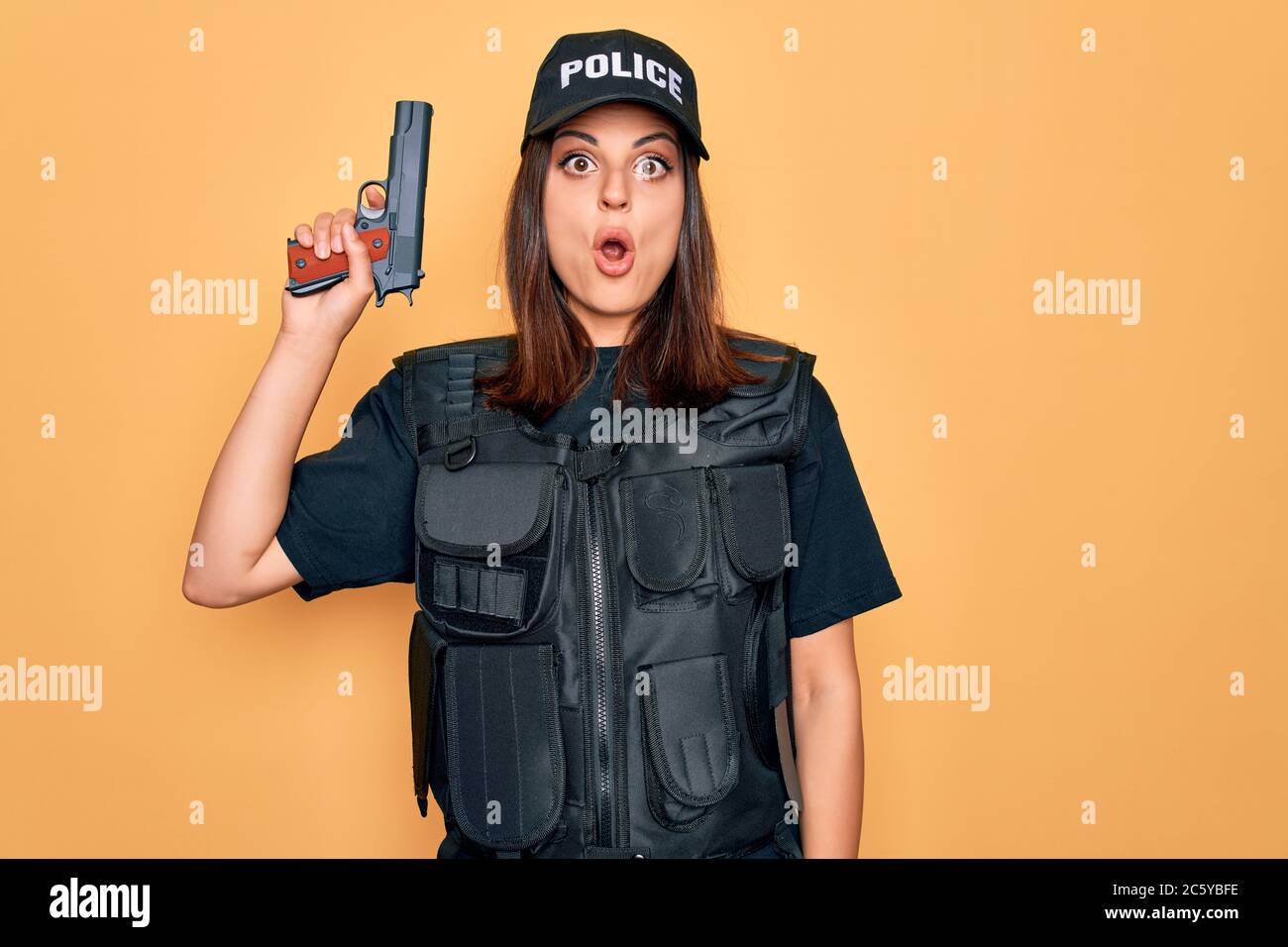 Young beautiful brunette policewoman wearing police uniform bulletproof ...