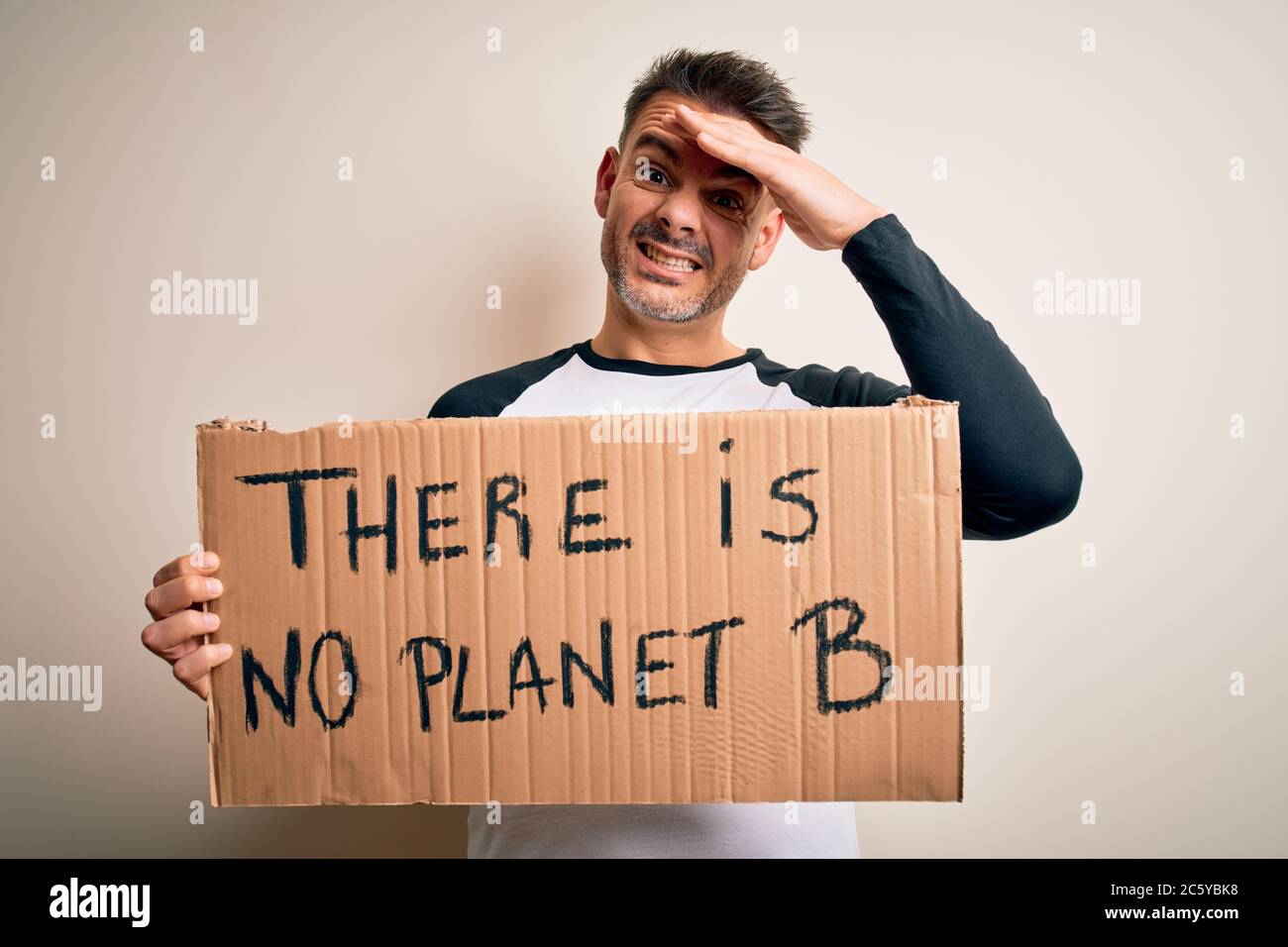 Young handsome man asking for environment holding banner with planet ...