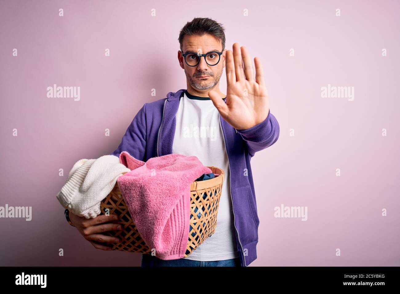 Young handsome man doing housework holding wicker basket with clothes ...