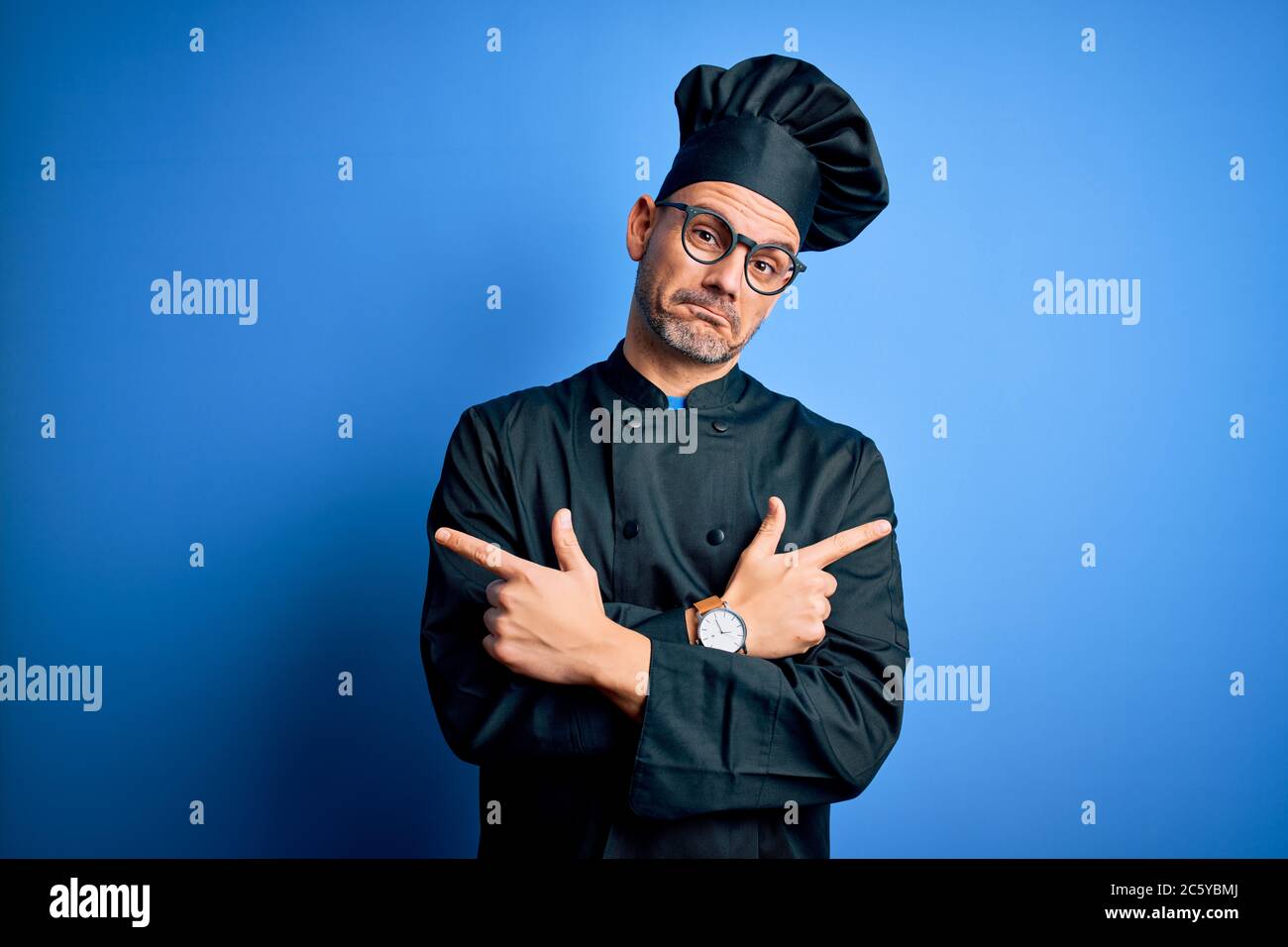 Young handsome chef man wearing cooker uniform and hat over isolated ...