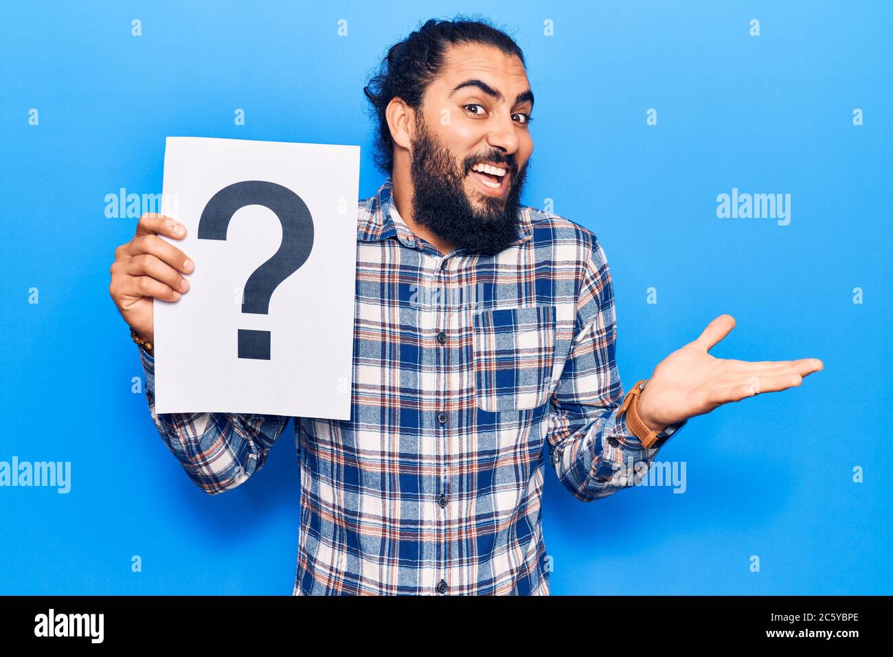 Young arab man holding question mark celebrating achievement with happy ...