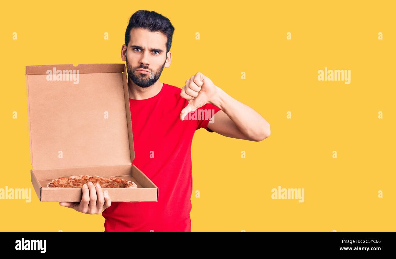 Young handsome man with beard holding delivery cardboard with italian ...