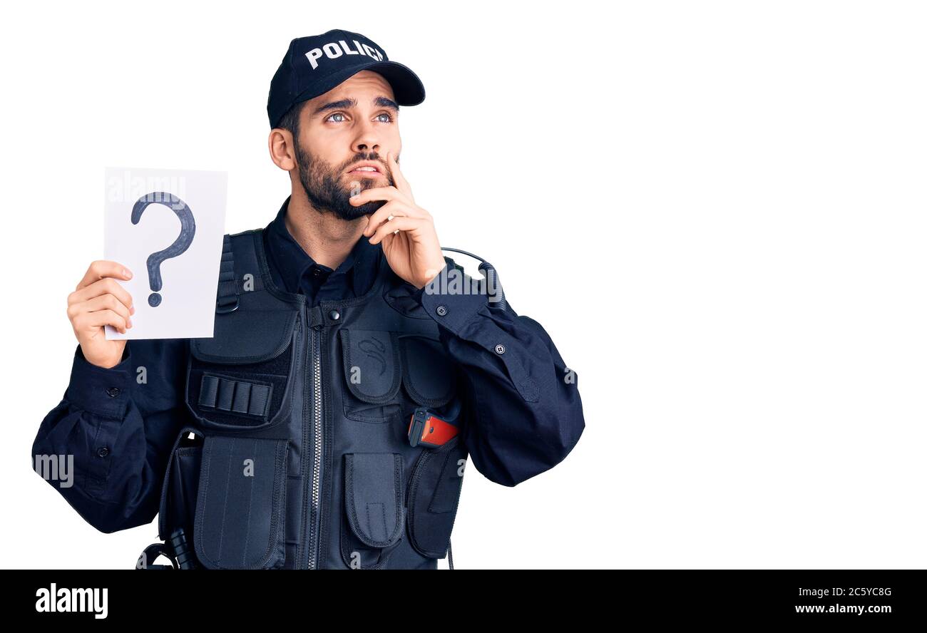 Young handsome man with beard wearing police uniform holding question ...