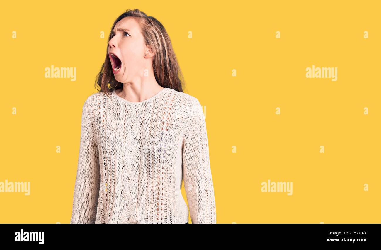 Young beautiful blonde woman wearing casual sweater angry and mad ...