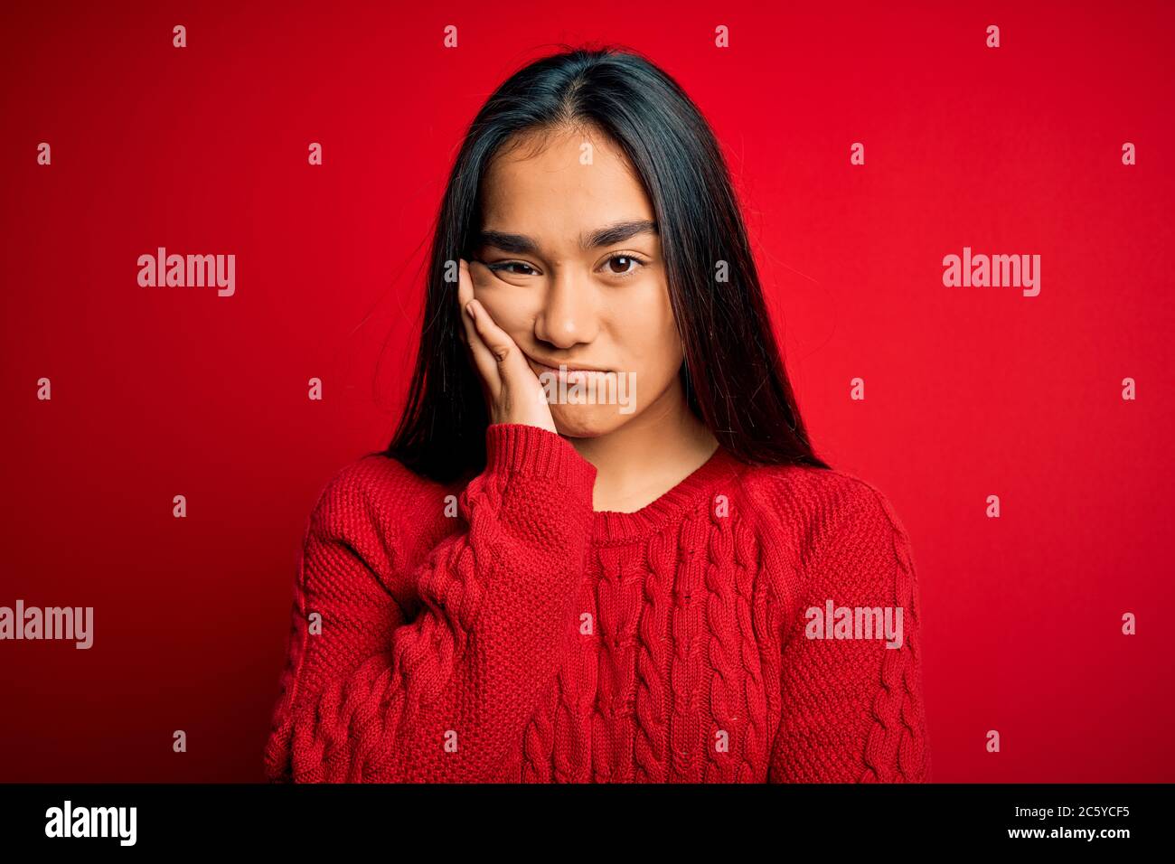 Young beautiful asian woman wearing casual sweater standing over ...