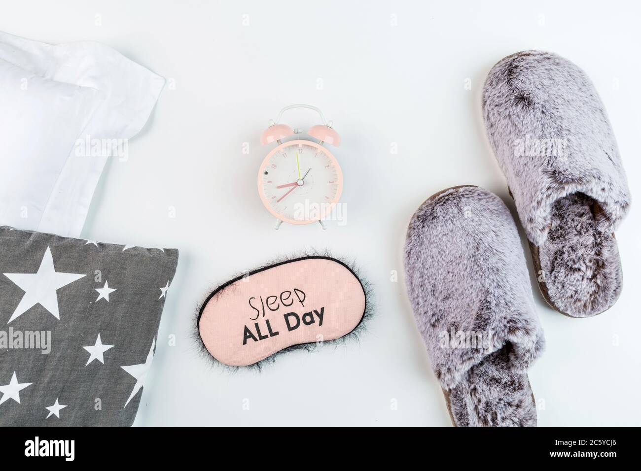 Flat lay with Soft fluffy slippers gray color, pillow, blindfold and ...