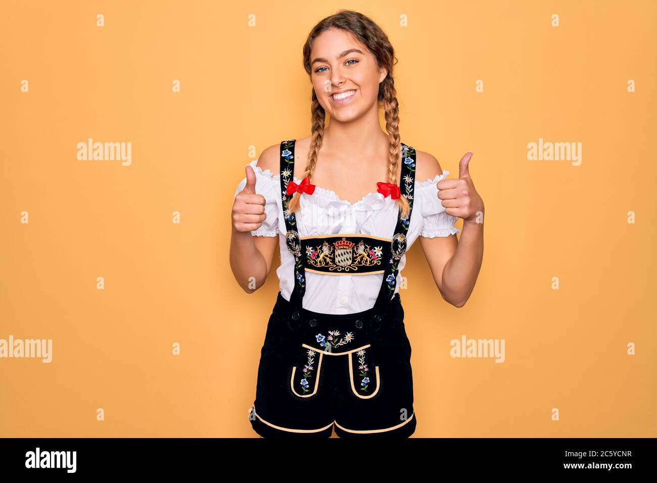 Young beautiful blonde german woman with blue eyes wearing traditional ...